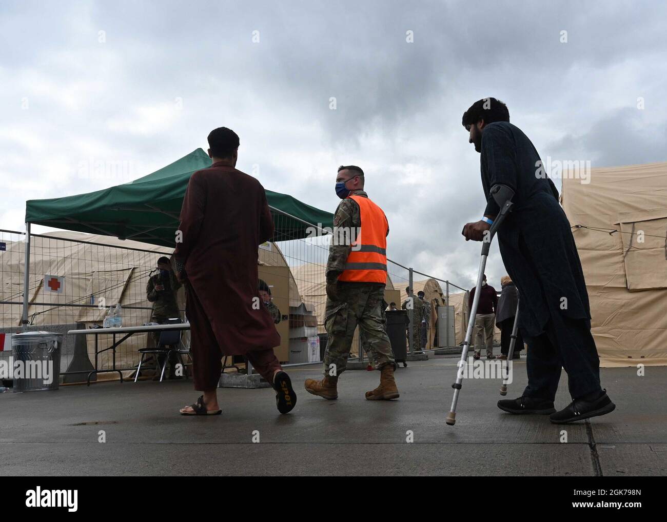 An Airman walks Afghan refugees to a medical tent during Operation ...