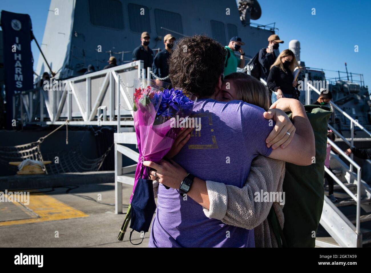 Ensign Rennie Scott is greeted by her husband on the pier during the ...