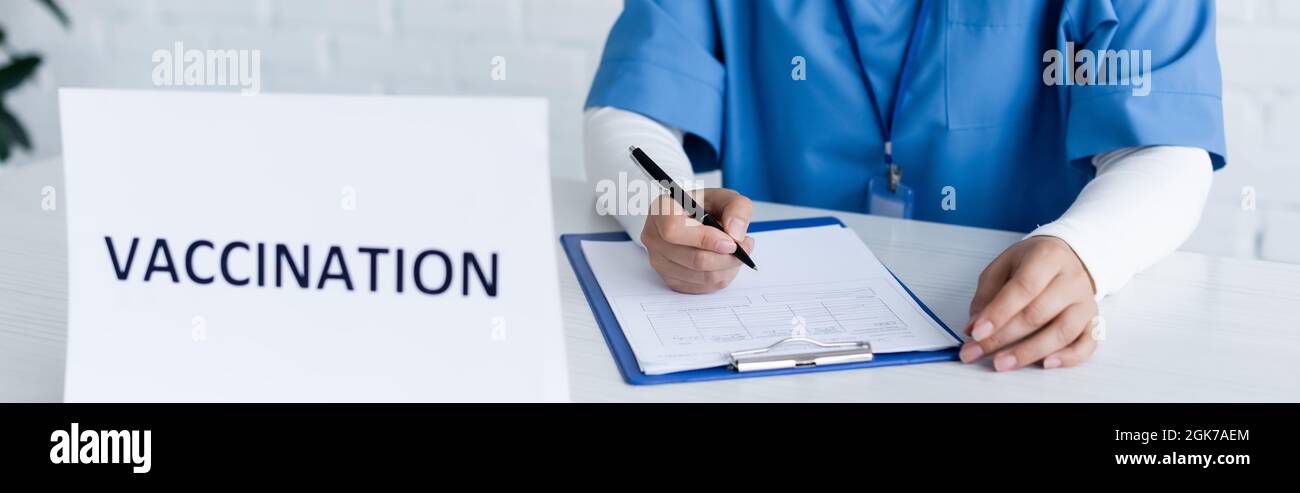 partial view of immunologist writing on medical card near vaccination ...