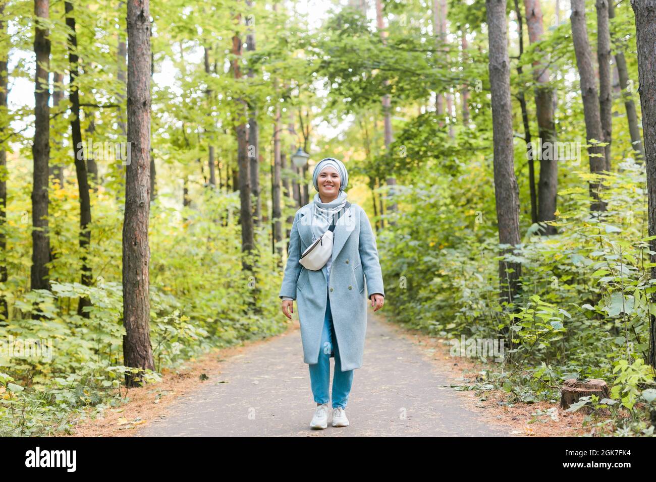 Islamic young woman wearing hijab standing on autumn park background ...