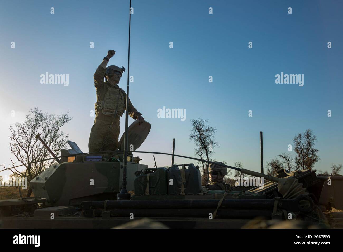 An Australian Army soldier gives a hand and arm signal to the convoy in ...