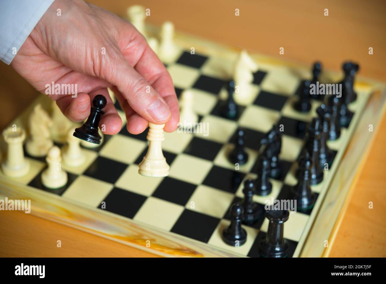 Chess: man's hand holding black and white pawns Stock Photo - Alamy