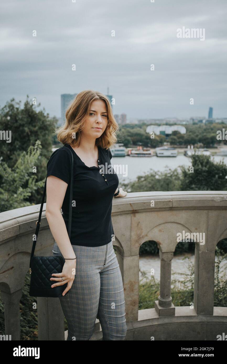 Vertical of a brunette young Bosnian female posing on the balcony ...