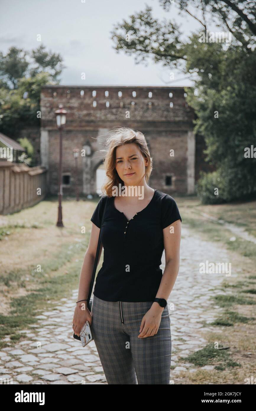 Vertical of a beautiful Bosnian female posing on the pathway against ...