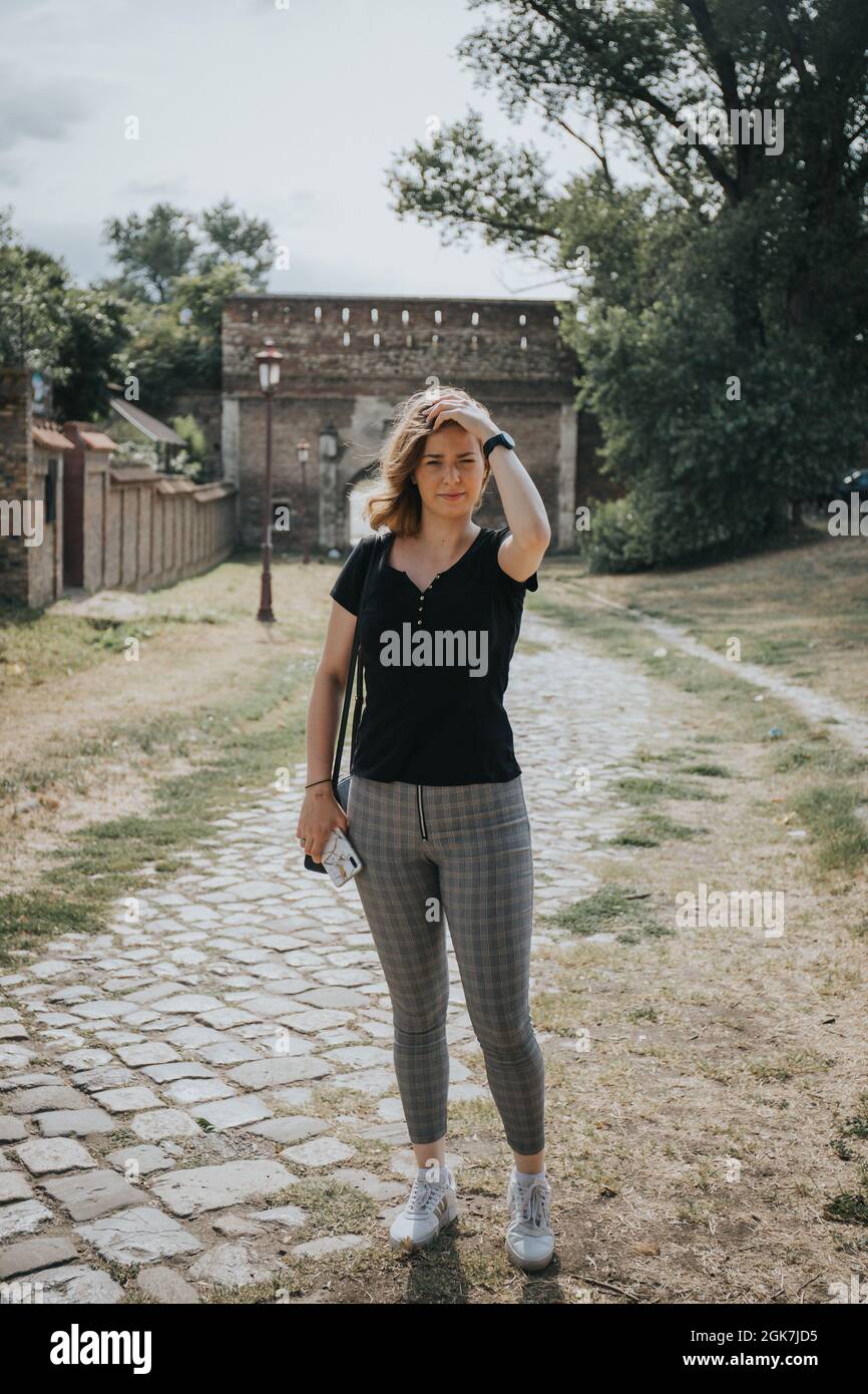 Vertical of a beautiful Bosnian female posing on the pathway against ...