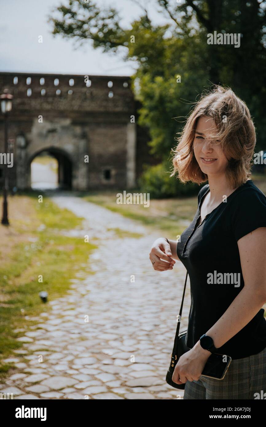 Side view of a beautiful Bosnian female posing on the pathway against ...