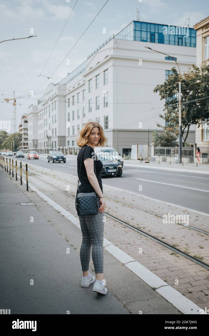 Vertical of a beautiful young Bosnian female posing on the sidewalk on ...