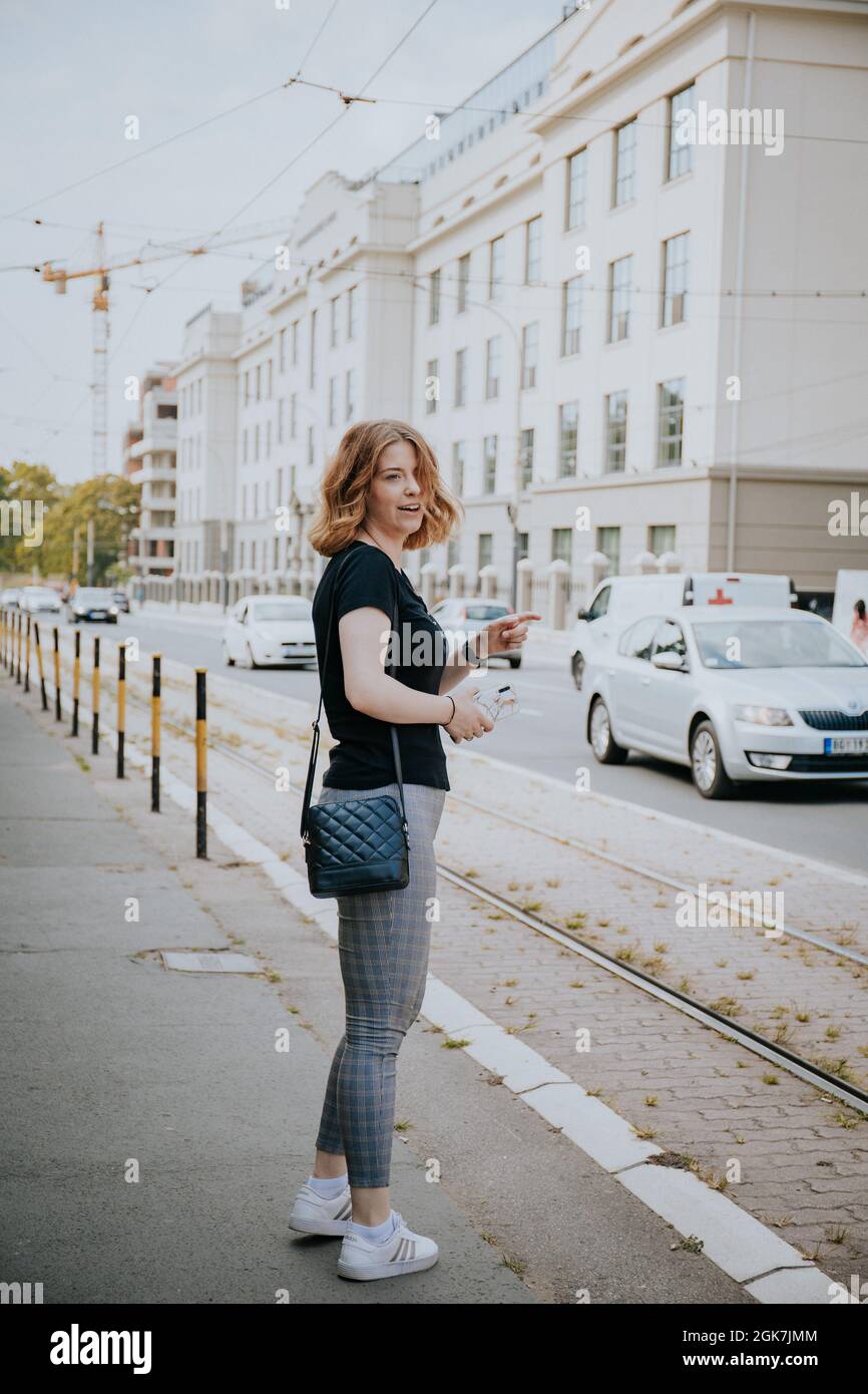 Vertical of a beautiful young Bosnian female posing on the sidewalk on ...
