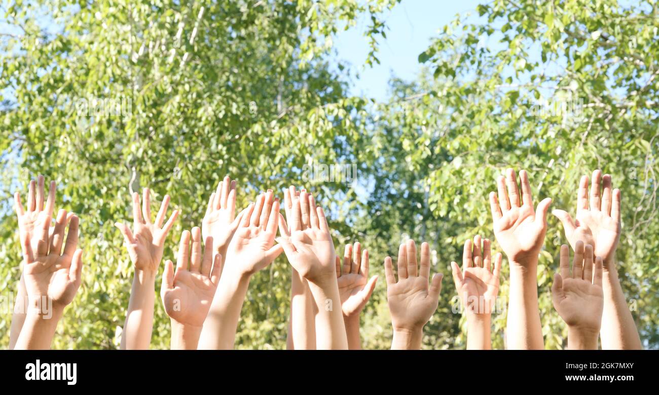 Young people putting hands in air together outdoors. Volunteering ...