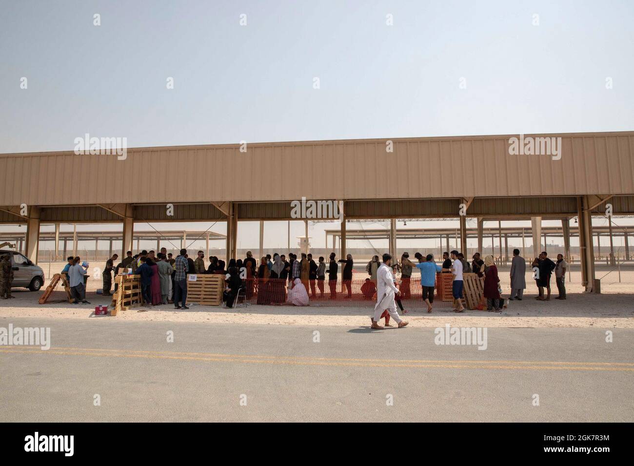 Afghans line up in the shade for sick call at Camp As Sayliyah, Qatar ...