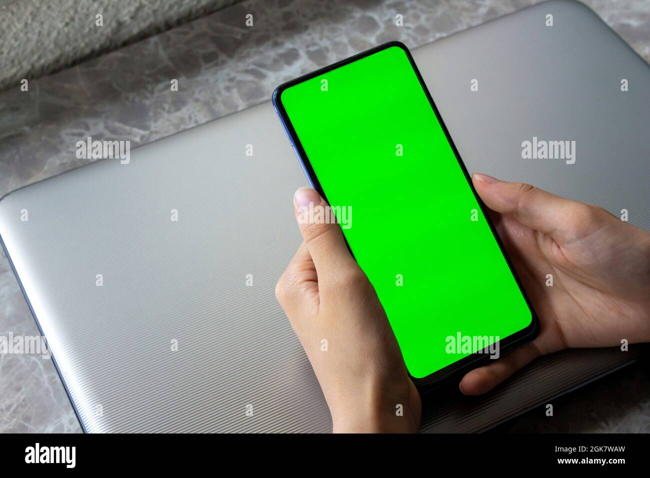 Mockup image of hand holding green screen mobile phone. Top view, copy ...