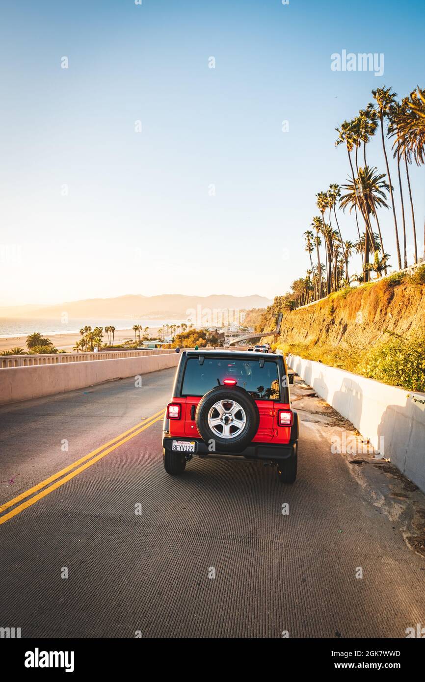 Red car riding on the road near the palm trees Stock Photo - Alamy