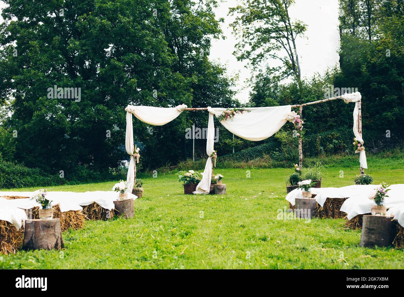 Beautiful outdoor wedding altar in nature with wooden log seats on a ...