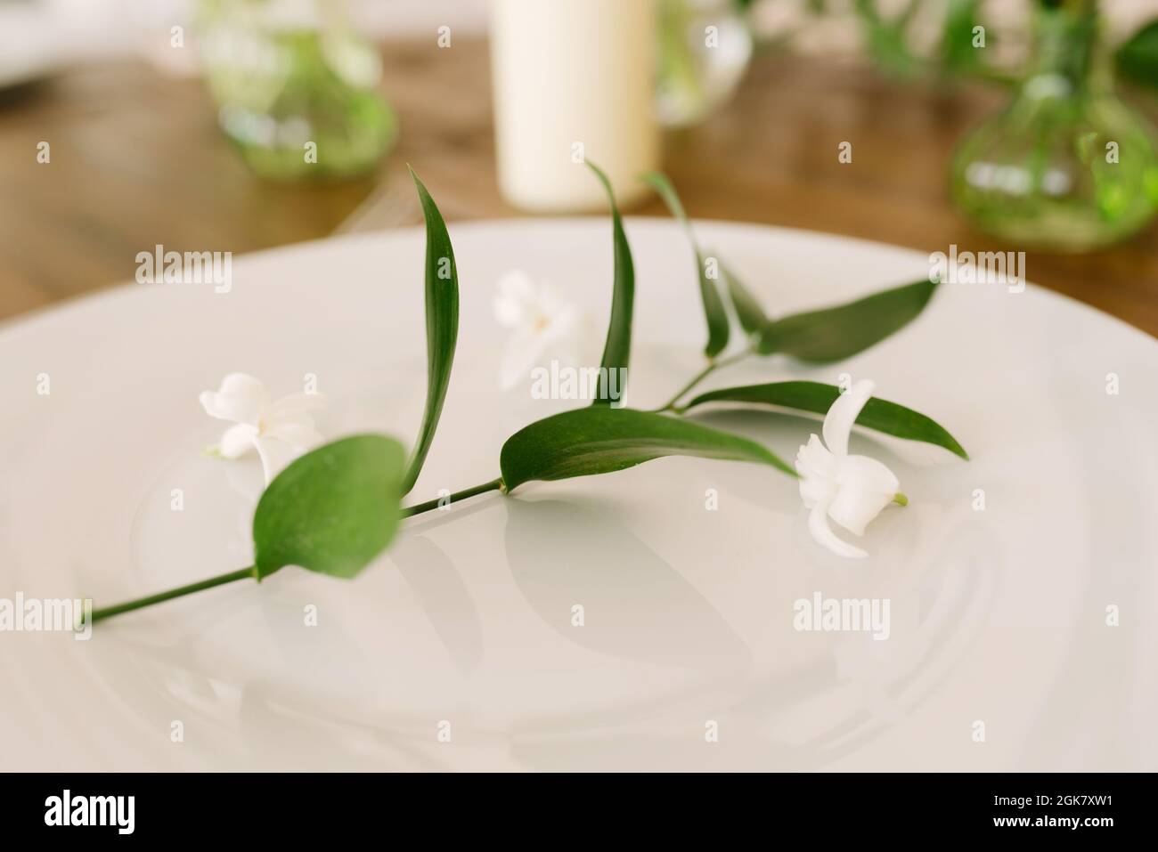 A green sprig with leaves on a serving plate on the festive table ...