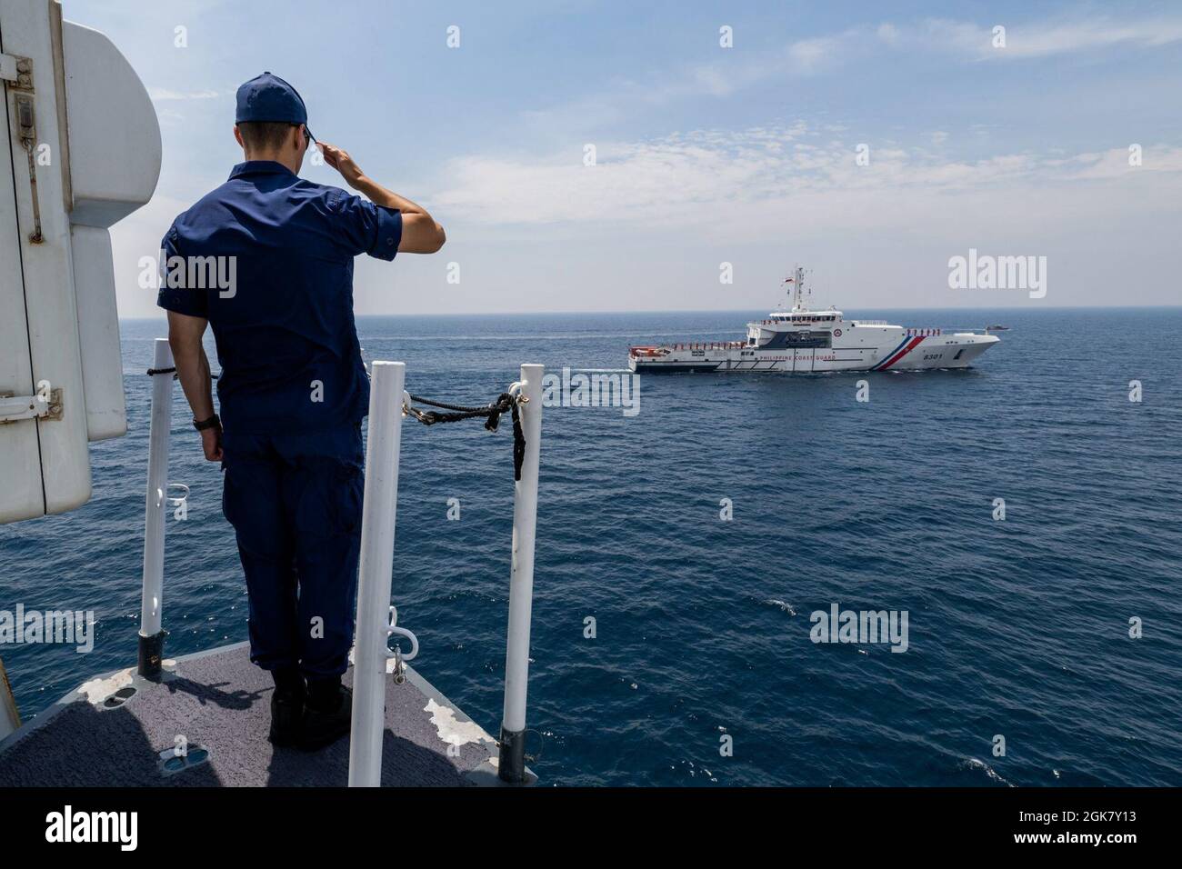 A crewmember from the U.S. Coast Guard Cutter Munro salutes a ...
