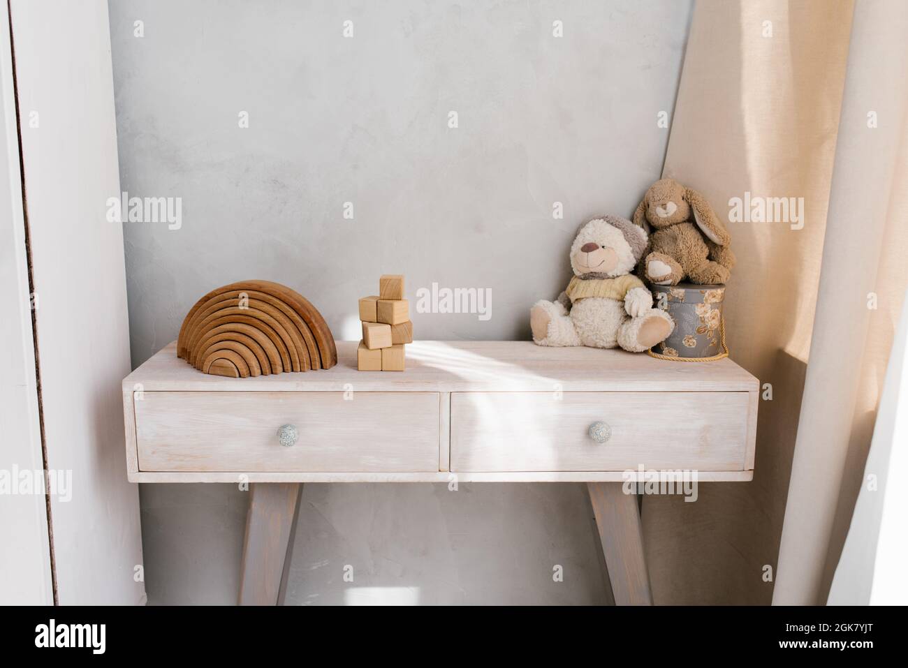 Wooden chest of drawers with children's soft and wooden toys in the ...