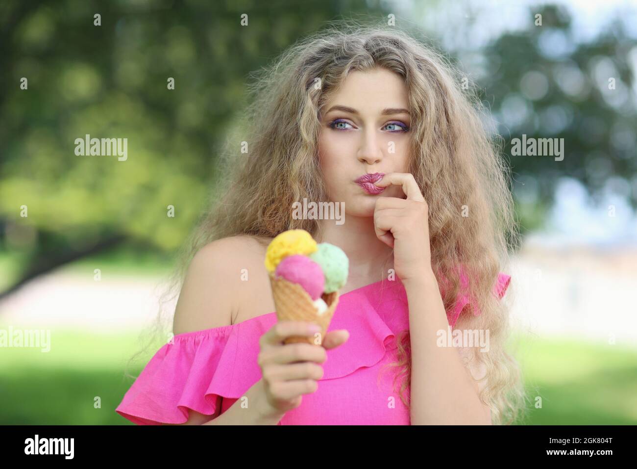 Beautiful young woman eating ice cream outdoors Stock Photo - Alamy