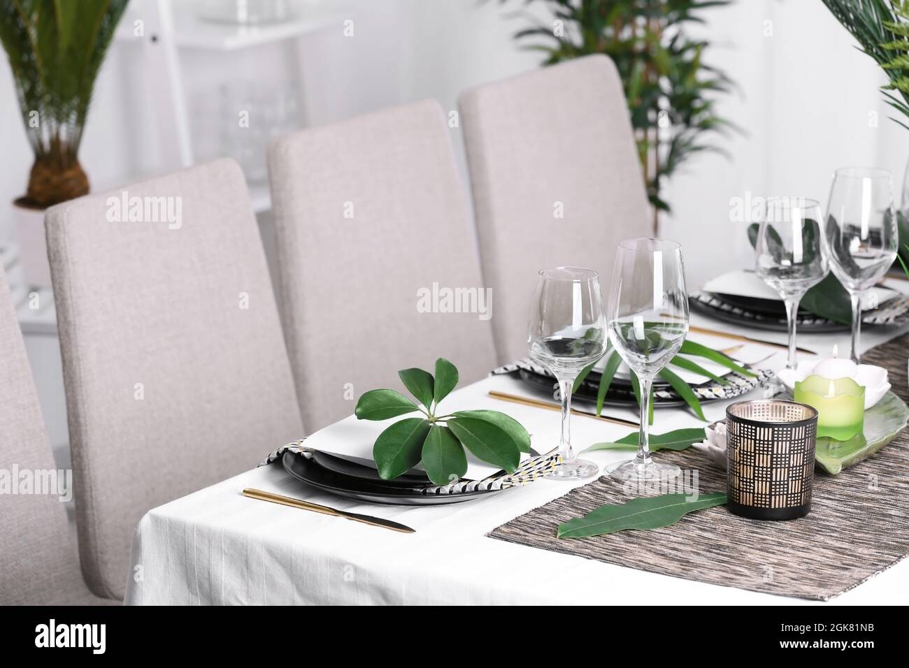 Beautiful table setting with green tropical leaves Stock Photo - Alamy