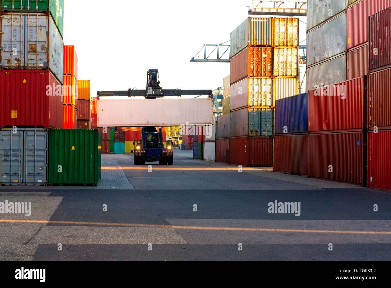 Crane loading container for exports next to stacked containers in ...