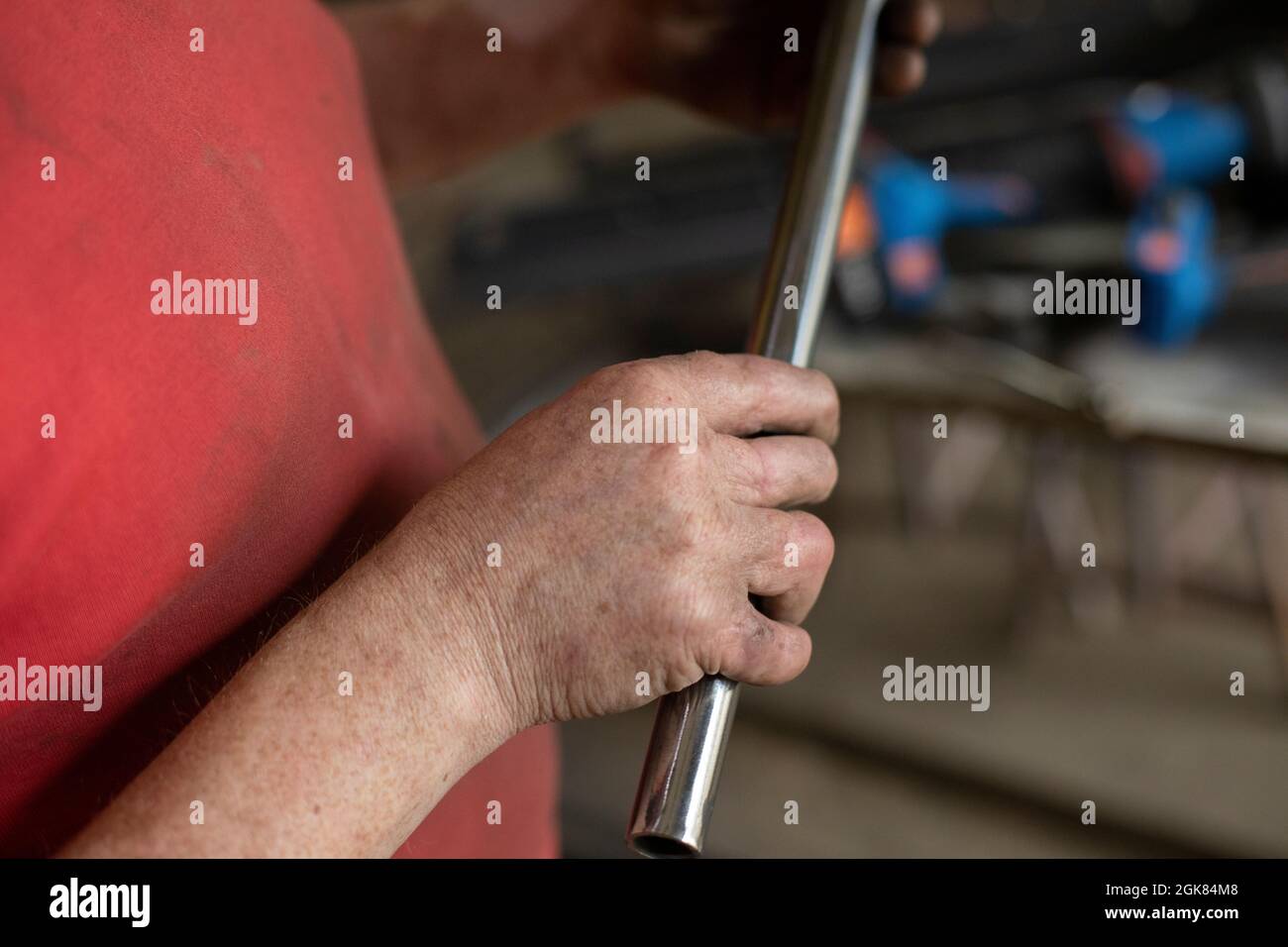 Steel pipe in hand. Small diameter of steel profile. A man holds a ...