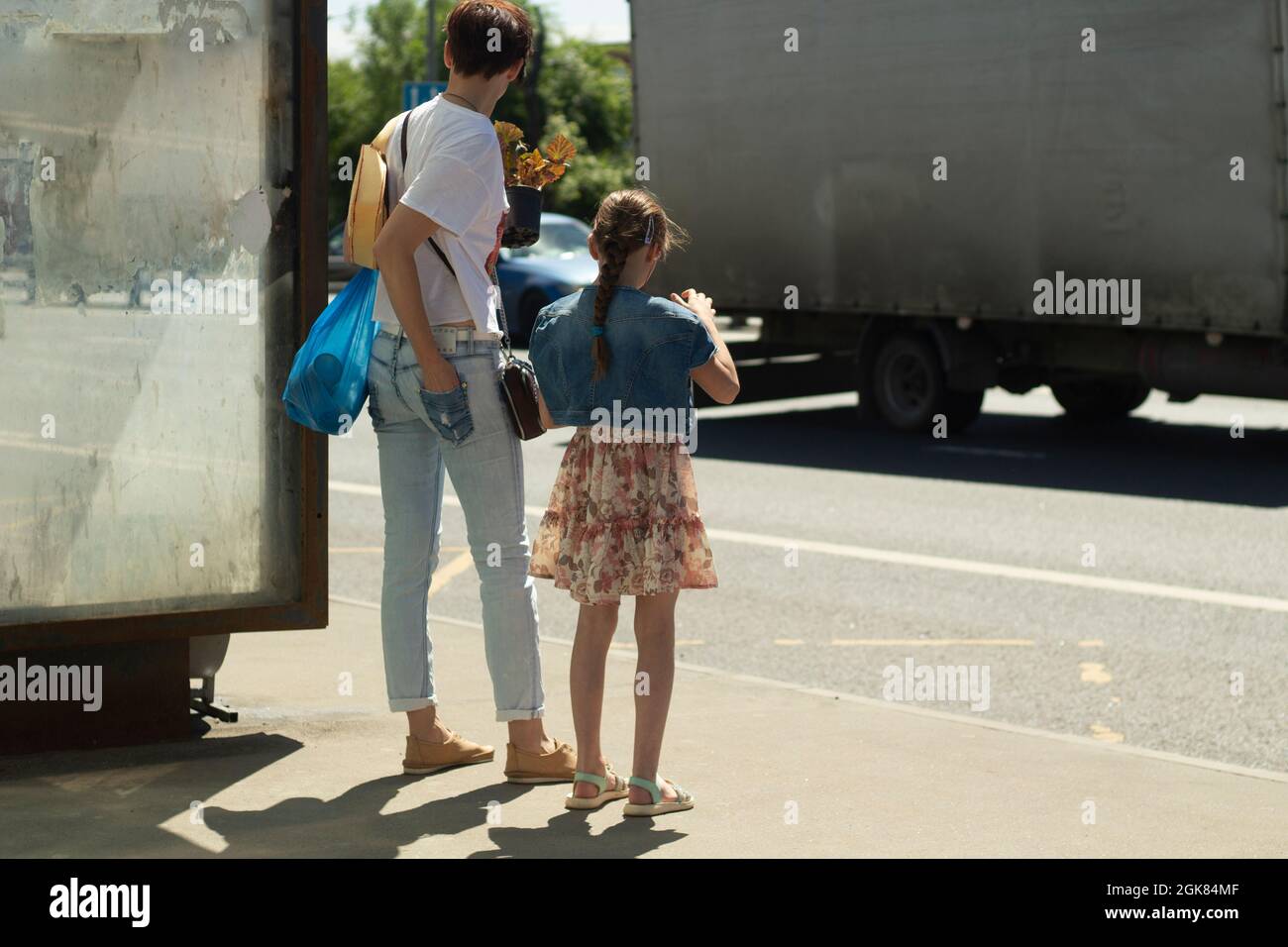 People at the bus stop. Waiting for transport. People stand by the road ...