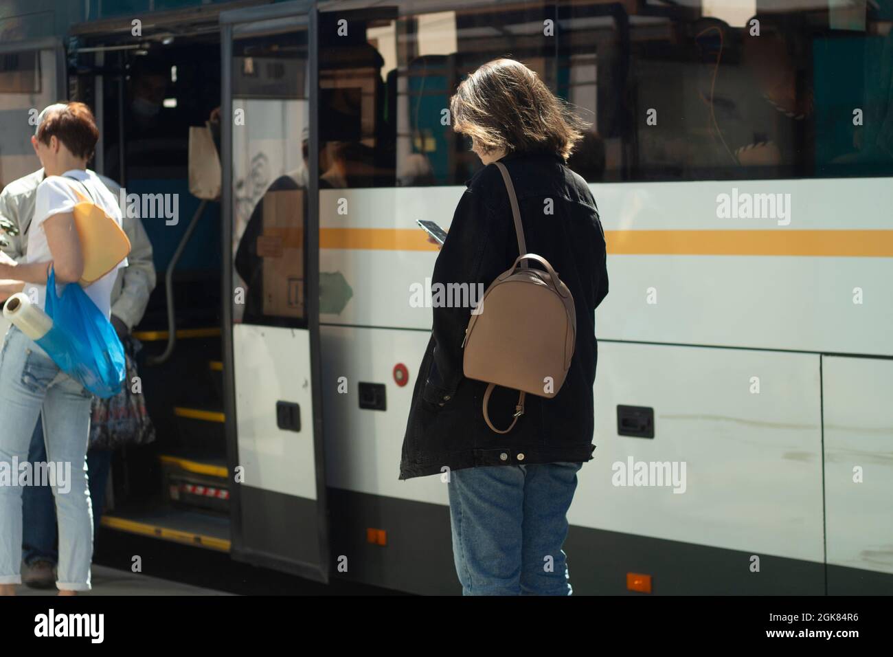 People at the bus stop. Waiting for transport. People stand by the road ...