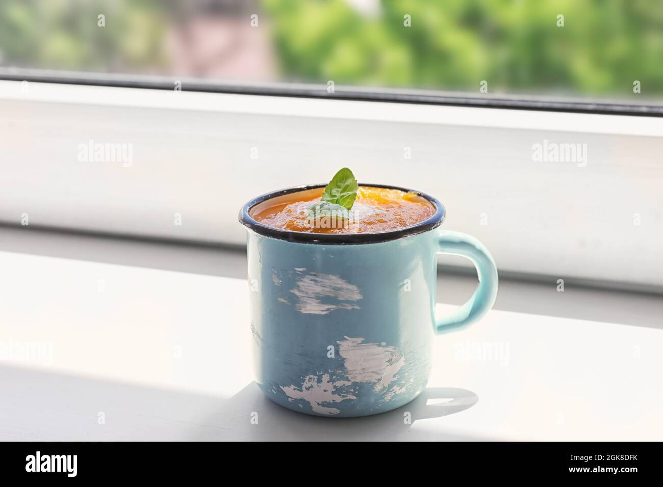 Cup with delicious carrot soup on window sill Stock Photo - Alamy