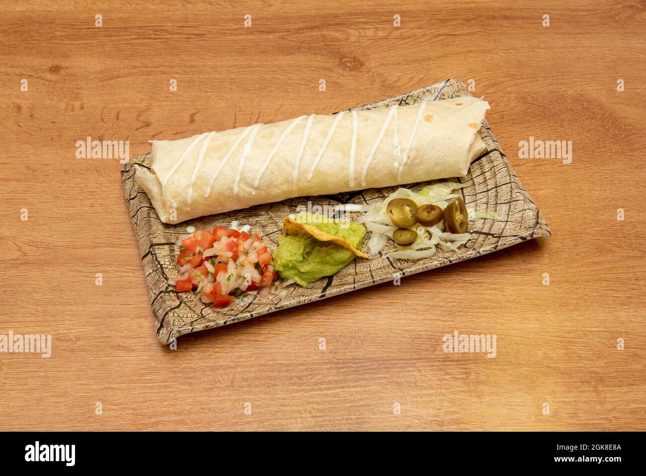 Large wheat tortilla burrito with salsa and garnishes of pico de gallo ...