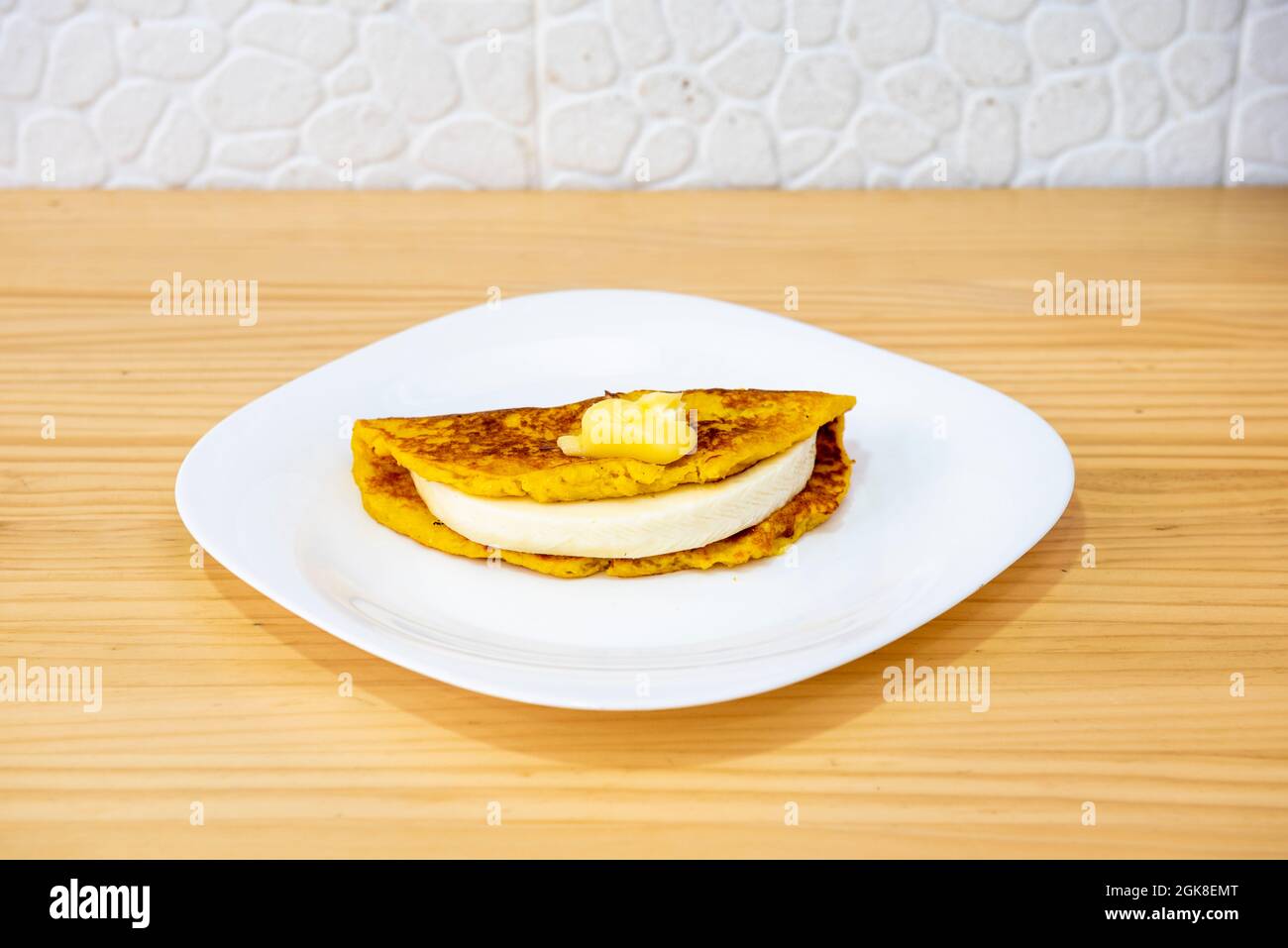 Corn cachapa filled with a good piece of melted fresh cheese and a ...