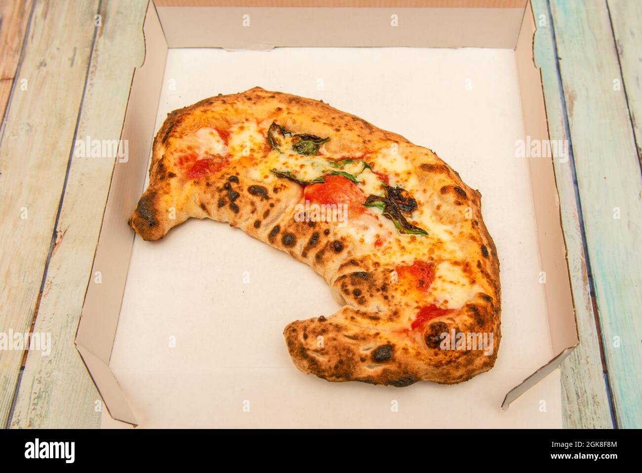 delicious looking calzone with melted cheese, cherry tomatoes and basil ...