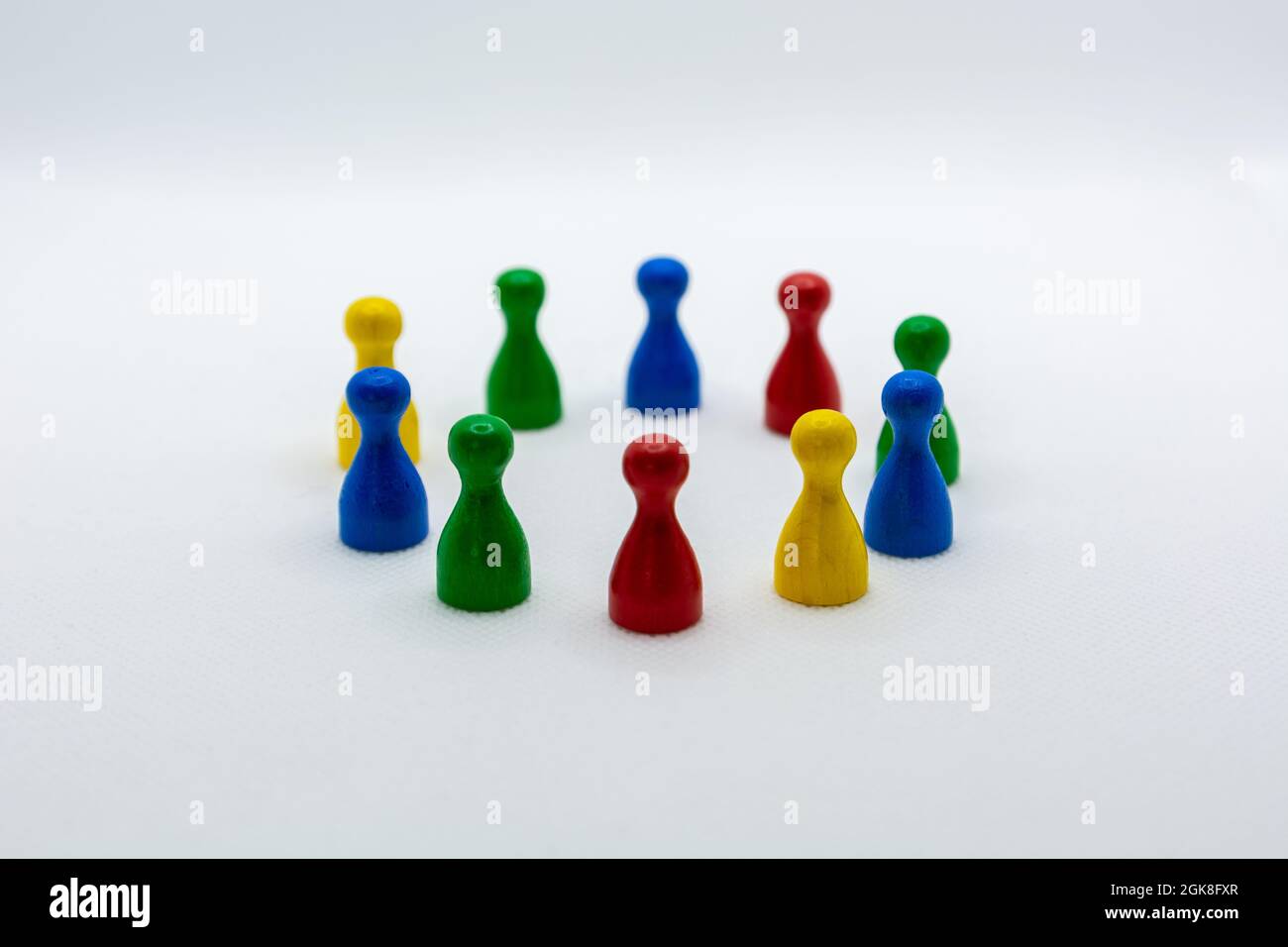 A group of colored pawns for board games arranged in a circle on a ...