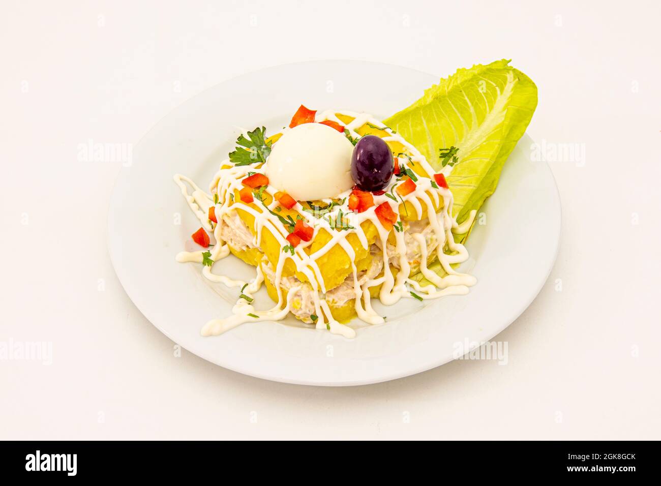 Top view image of a portion of Peruvian causa limeña garnished with ...