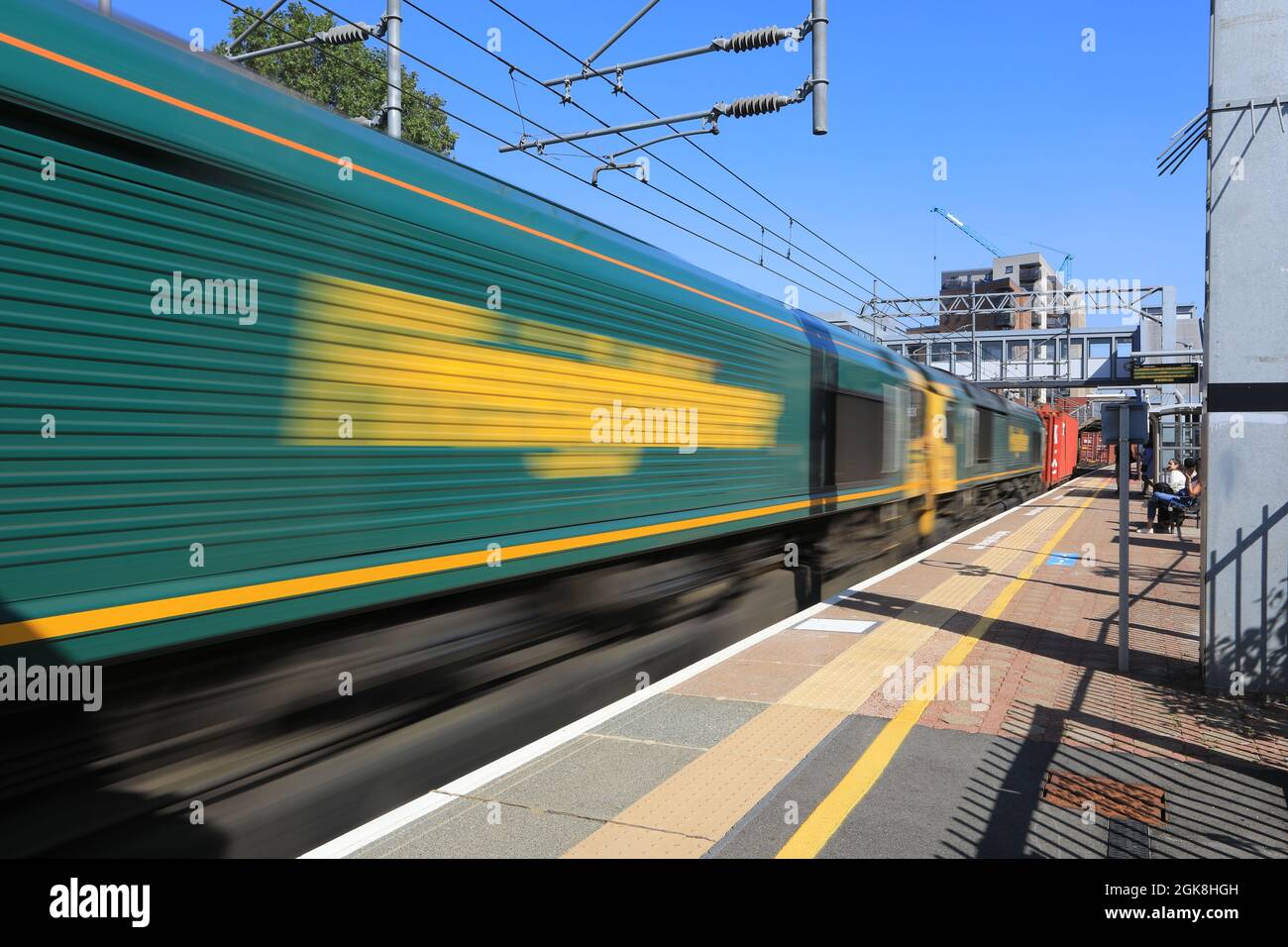 Colourful freight train travelling through Ealing station, west London ...