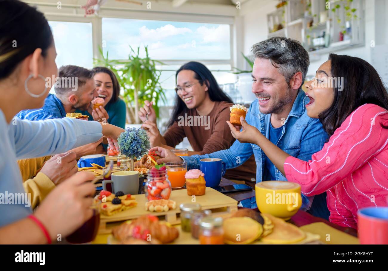 multiethnic group of friends sitting on a table in a bar restaurant ...