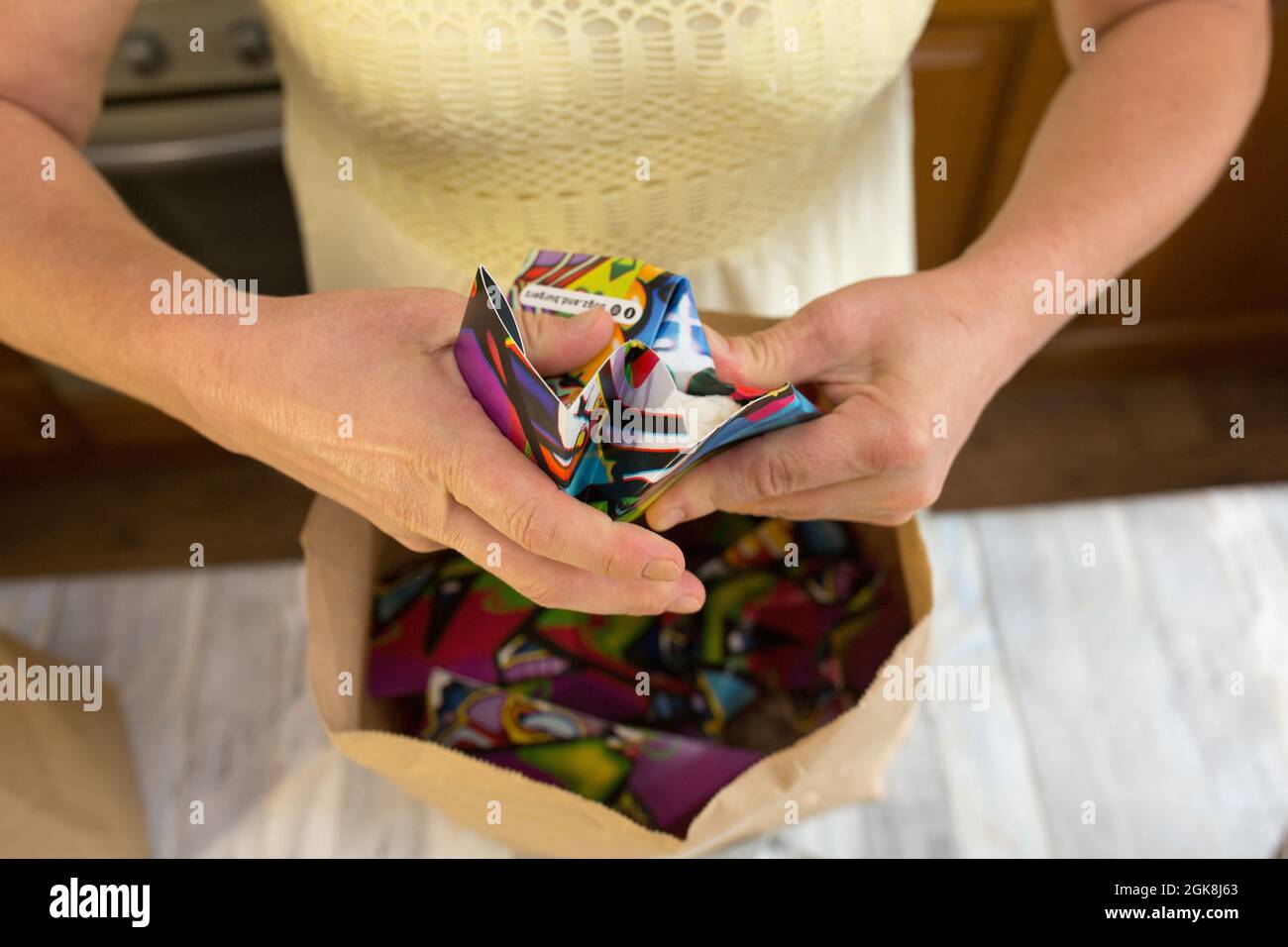 Female hands are wrapping paper bags from delivered food. Waste paper ...