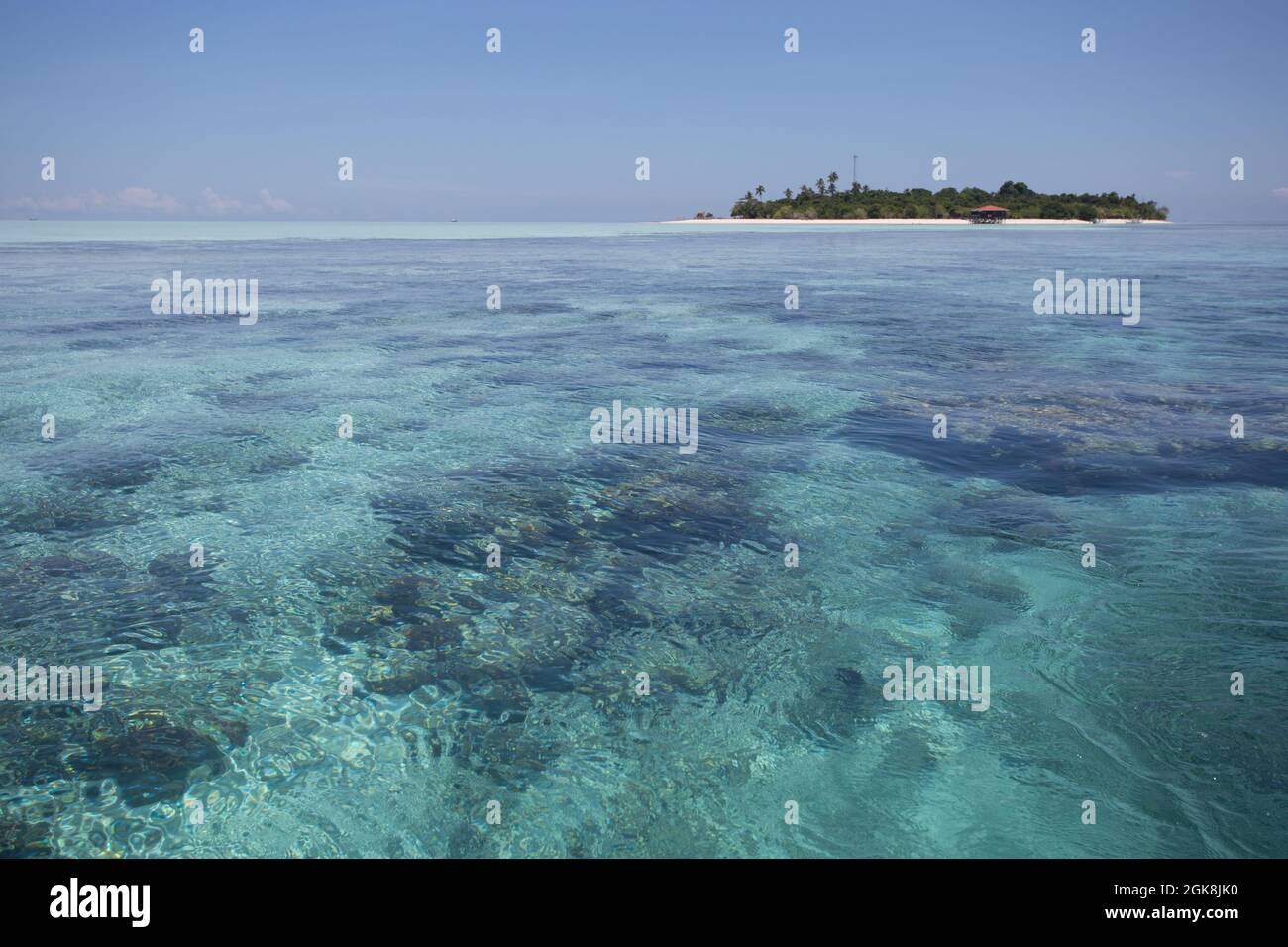 Transparent rippling water of endless sea with sandy bottom and island ...