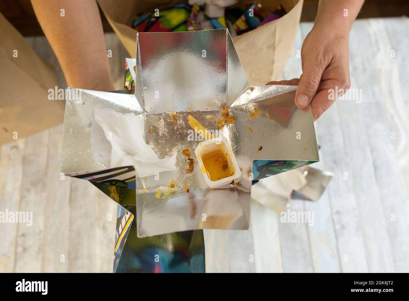Female hands are wrapping paper bags from delivered food. Waste paper ...