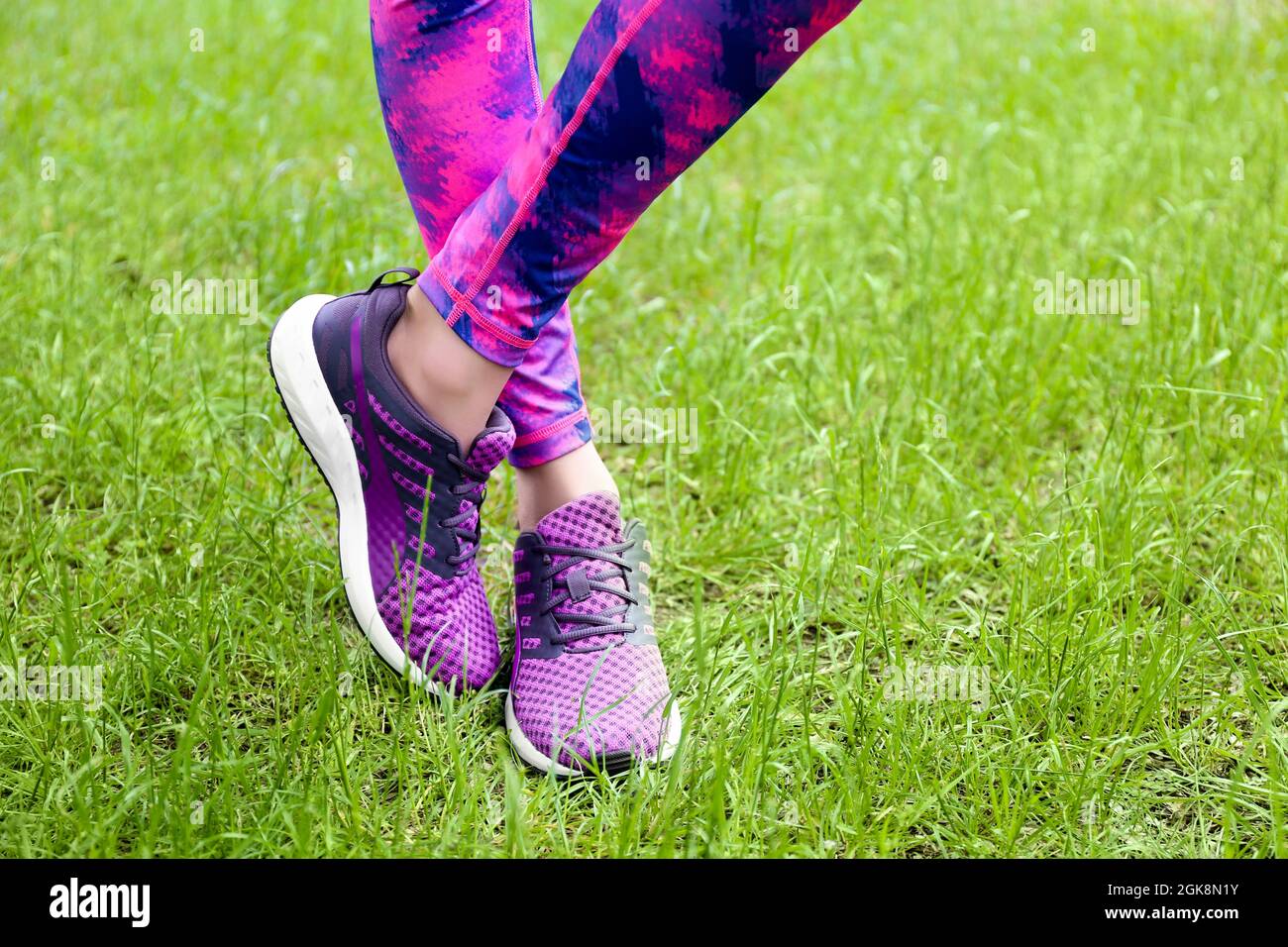 Female legs in leggings and purple sneakers on green grass Stock Photo ...