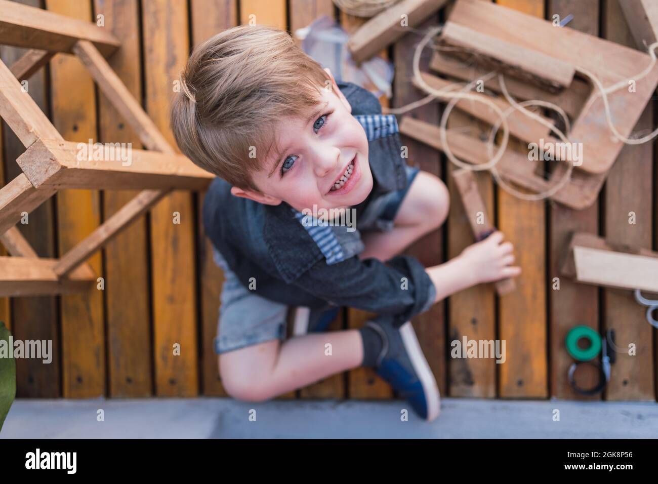 Top view of child with blue eyes and crossed legs looking at camera ...