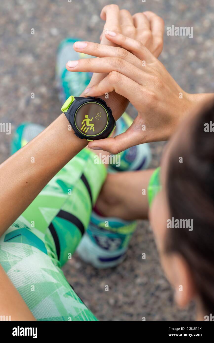 From above of crop anonymous female runner checking pulse on modern ...