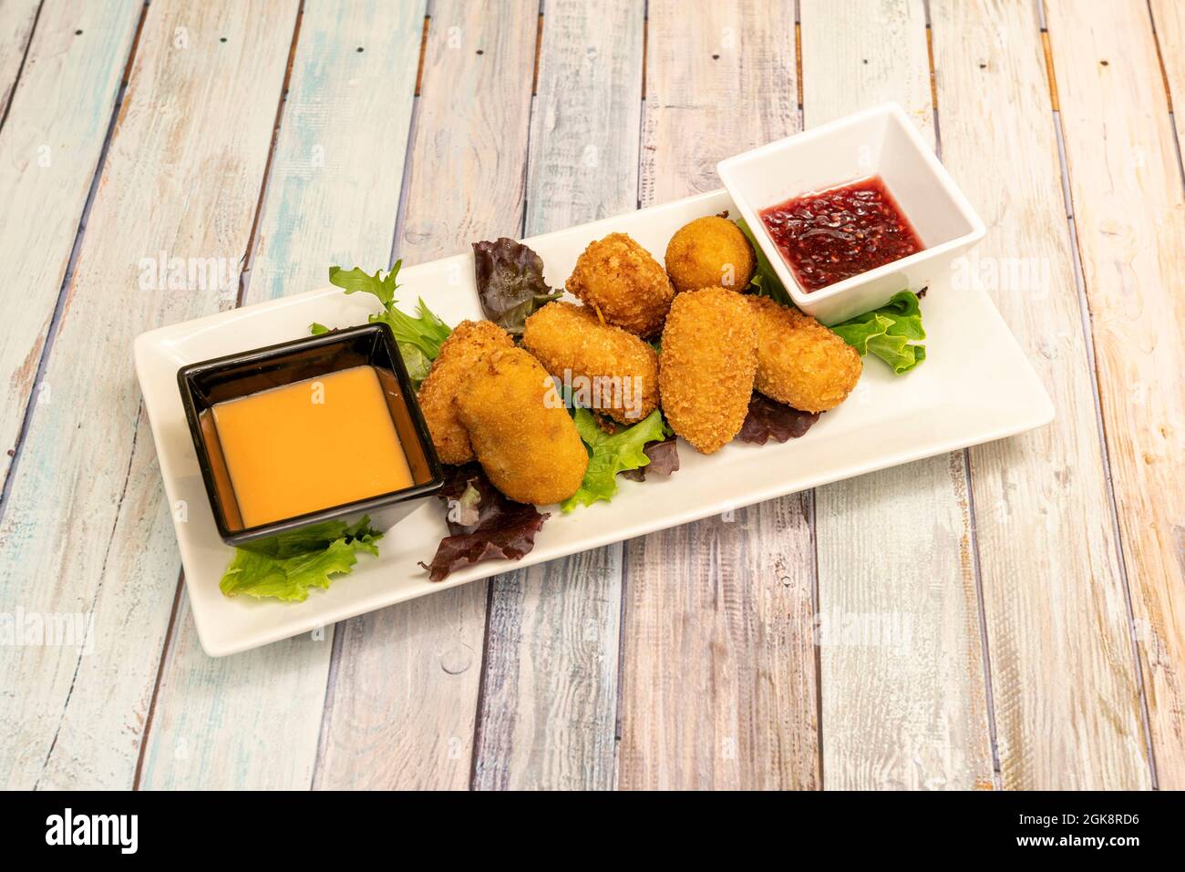 Portion of mixed chicken, serrano ham and cod croquettes with dipping ...