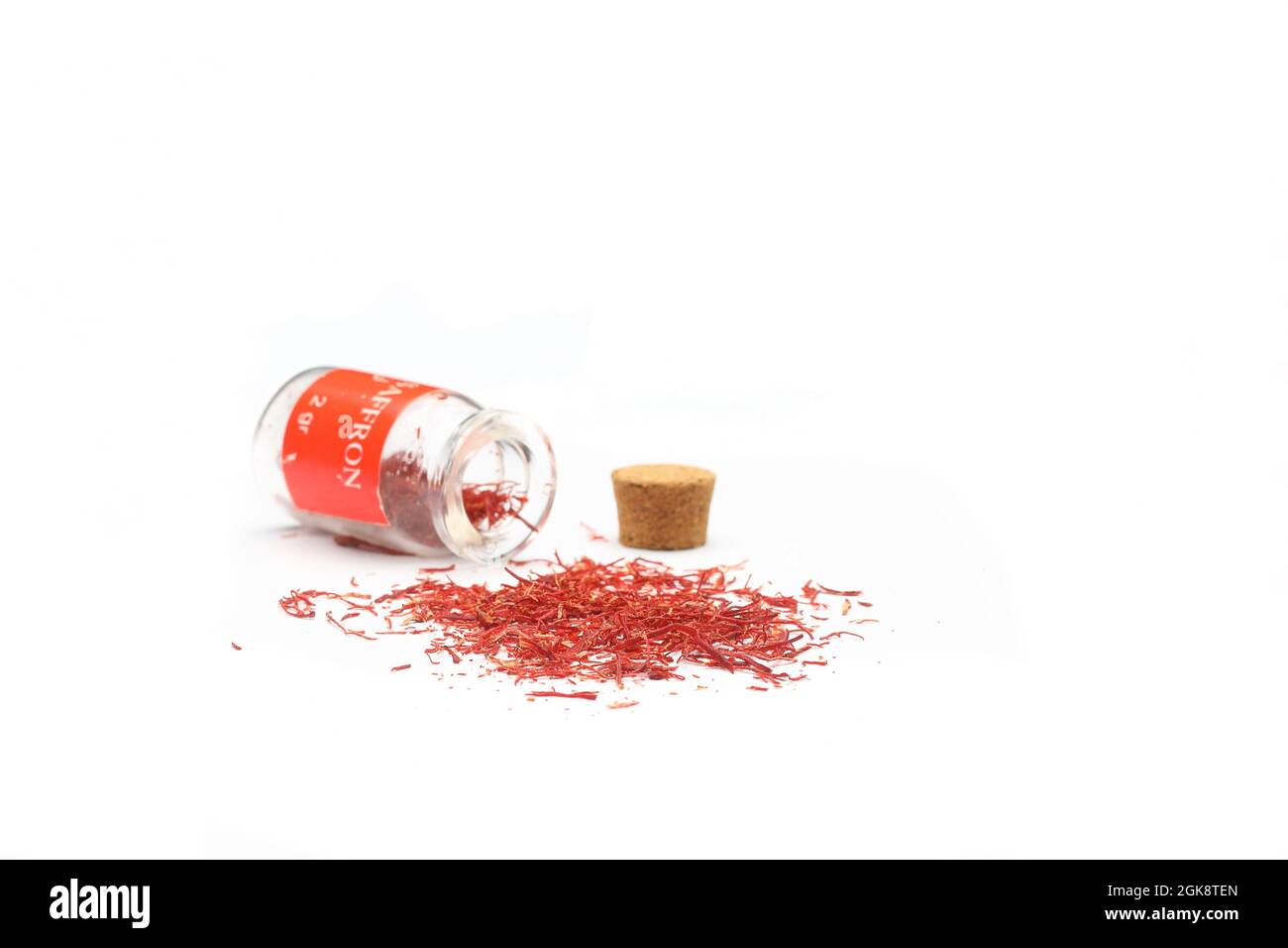 saffron poured from a little glass bottle on white background Stock ...