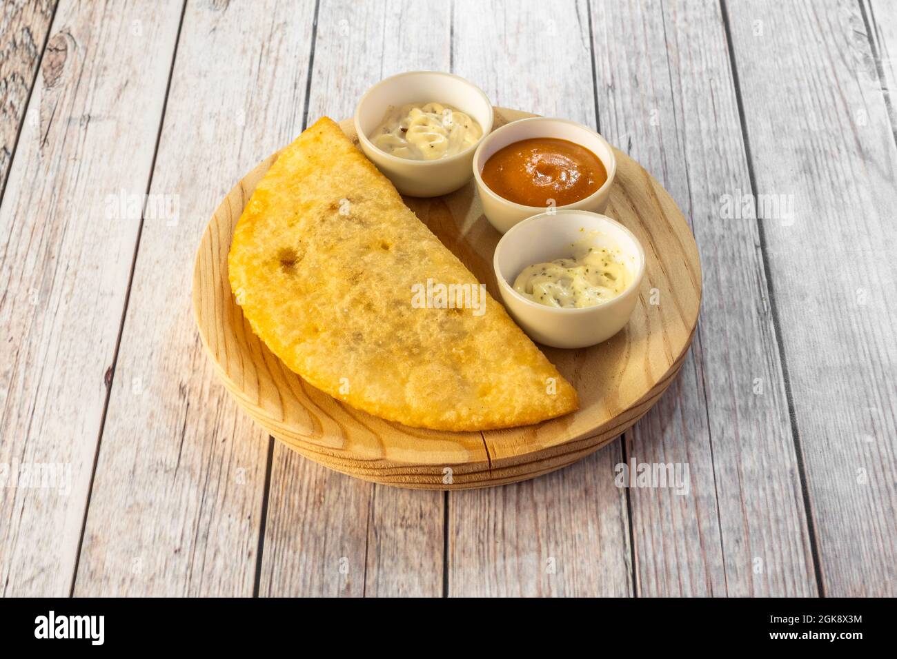 large yellow cornmeal patty stuffed with chicken meat with dip sauces ...