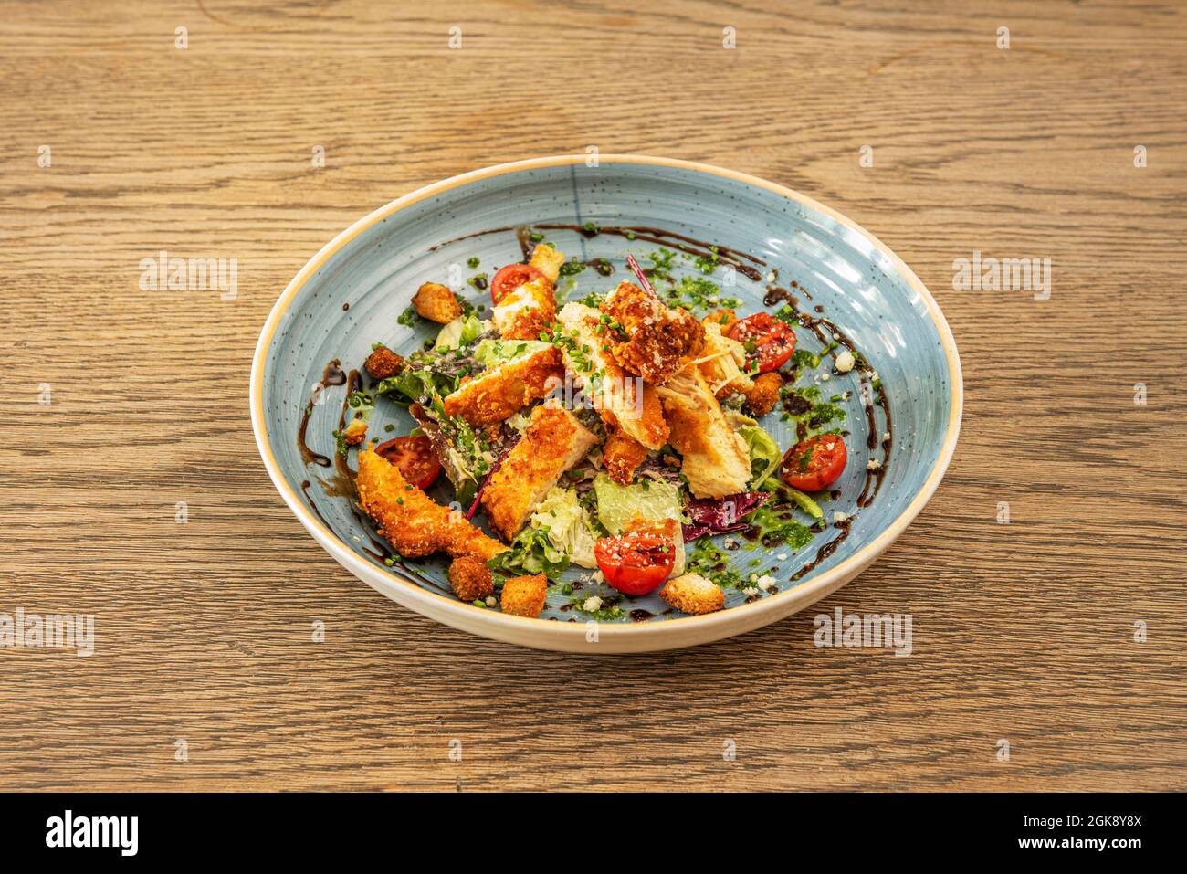 Caesar salad with fresh ingredients, split cherry tomatoes and chives ...