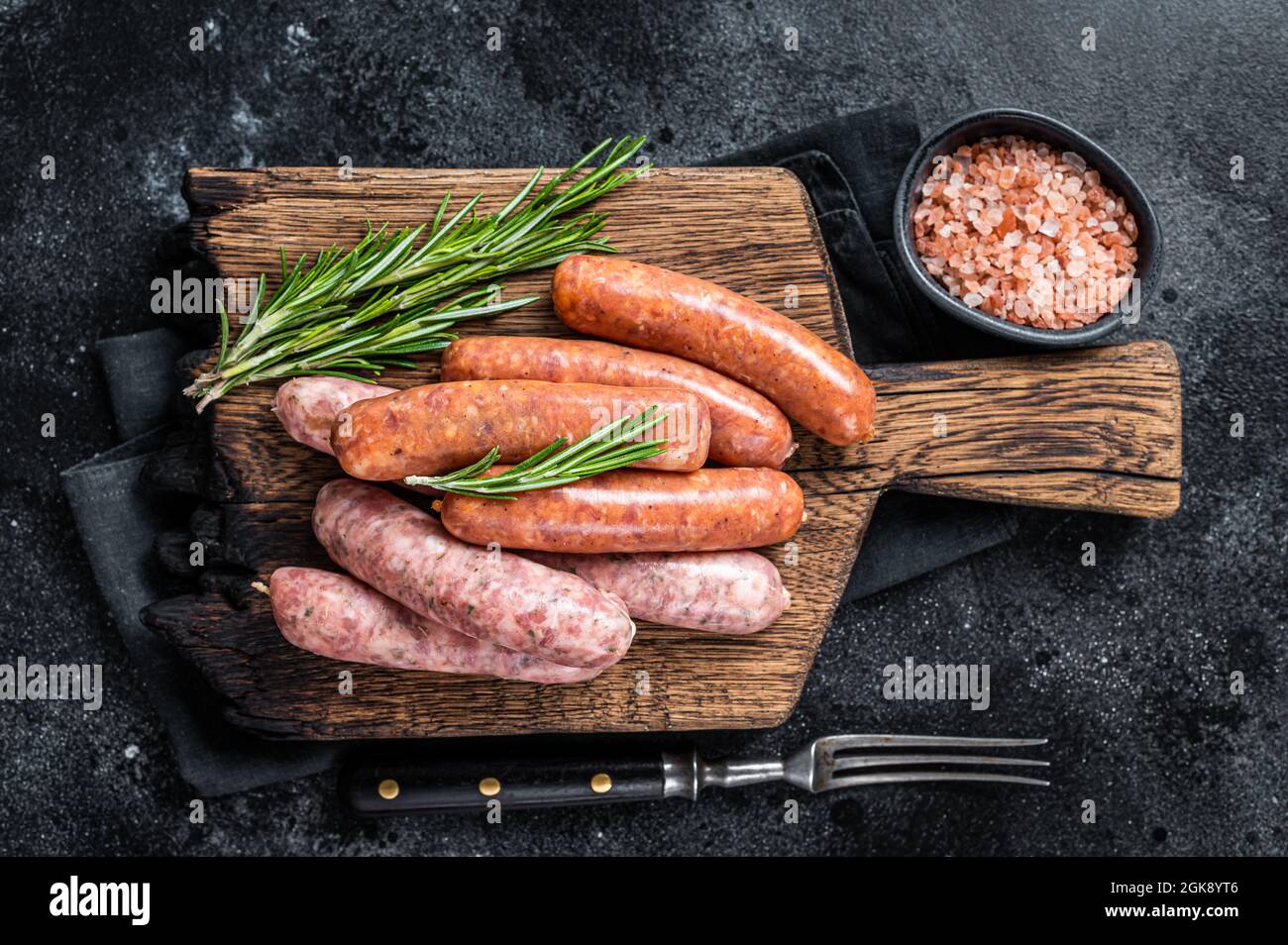 Uncooked Raw sausages Chorizo and Bratwurst with spices on wooden board ...
