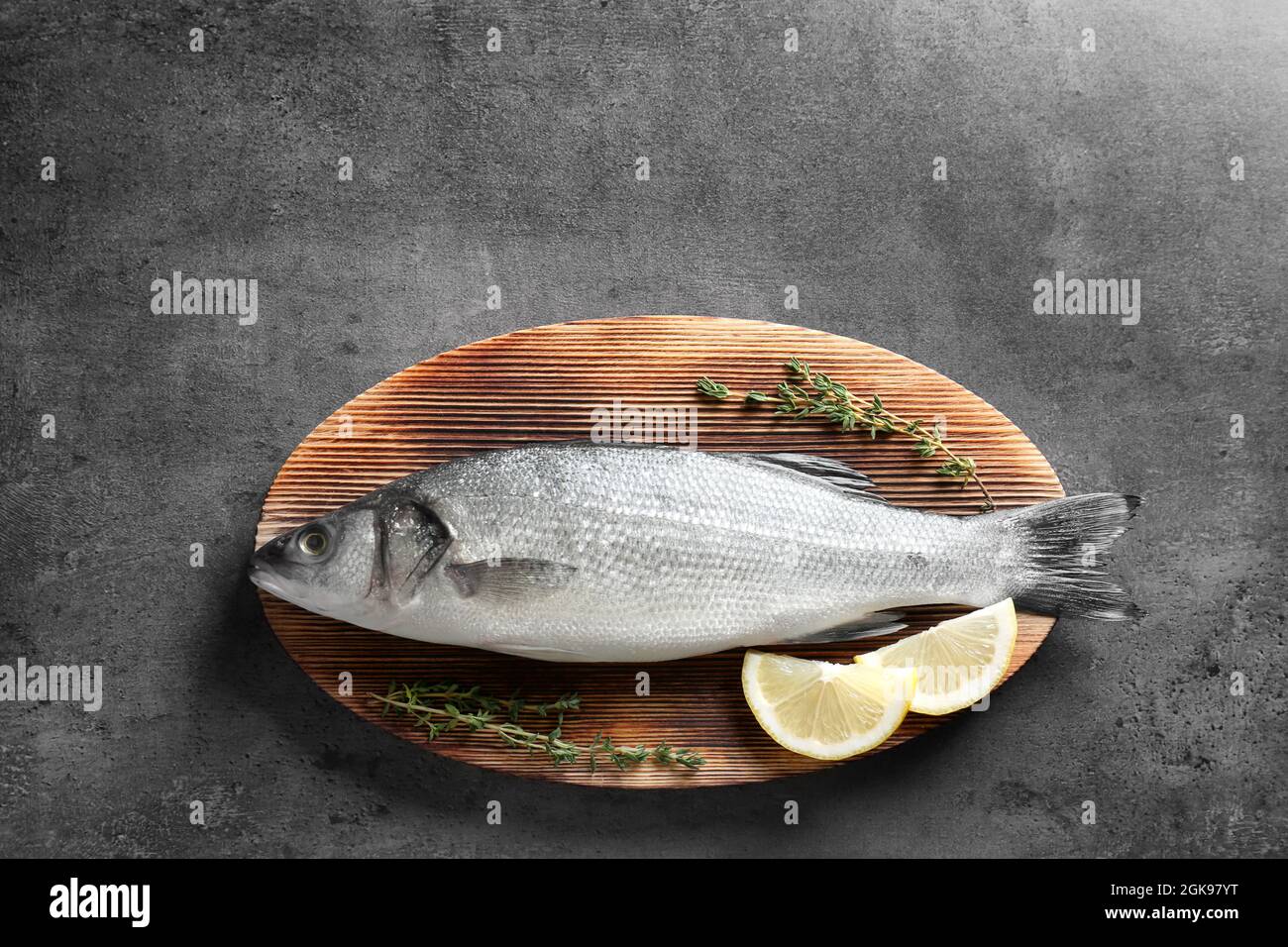 Fresh fish with thyme and lemon on gray background Stock Photo - Alamy