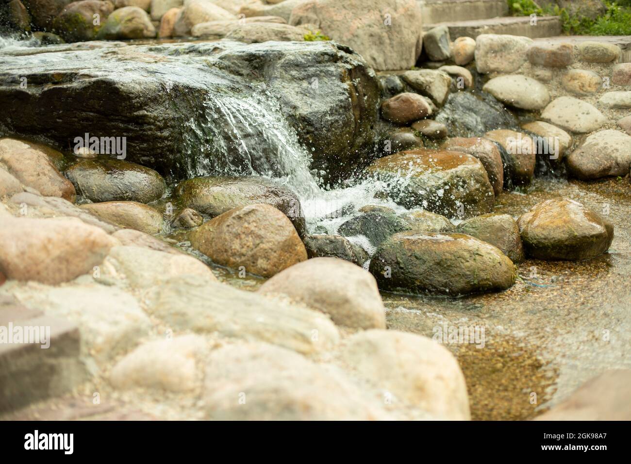 Waterfall among the stones. Artificial pond. Landscape design with ...