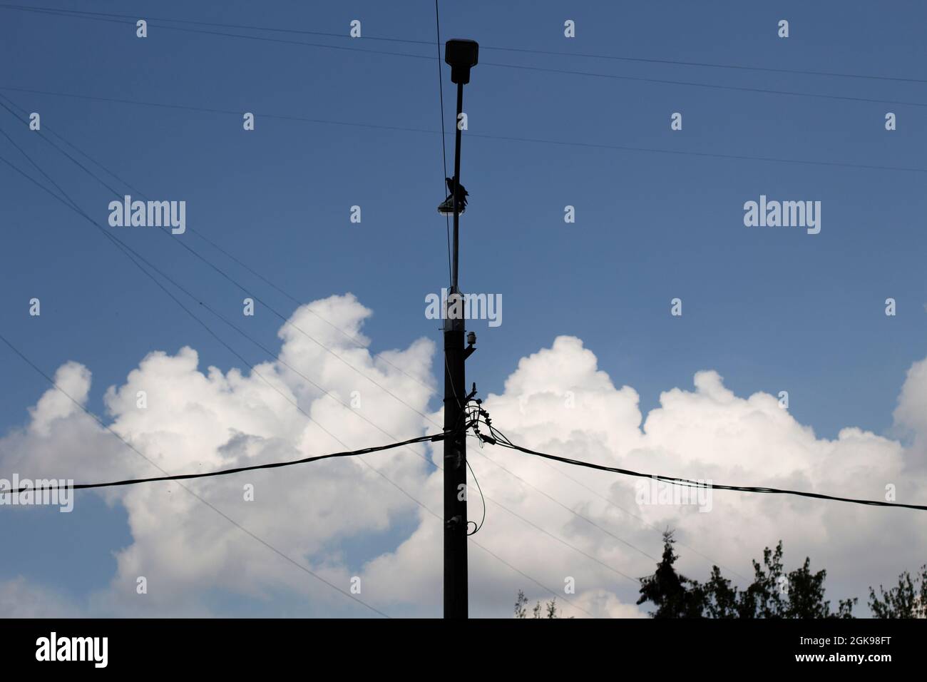 A fan pole against the clouds. A pillar without light. The lights off ...