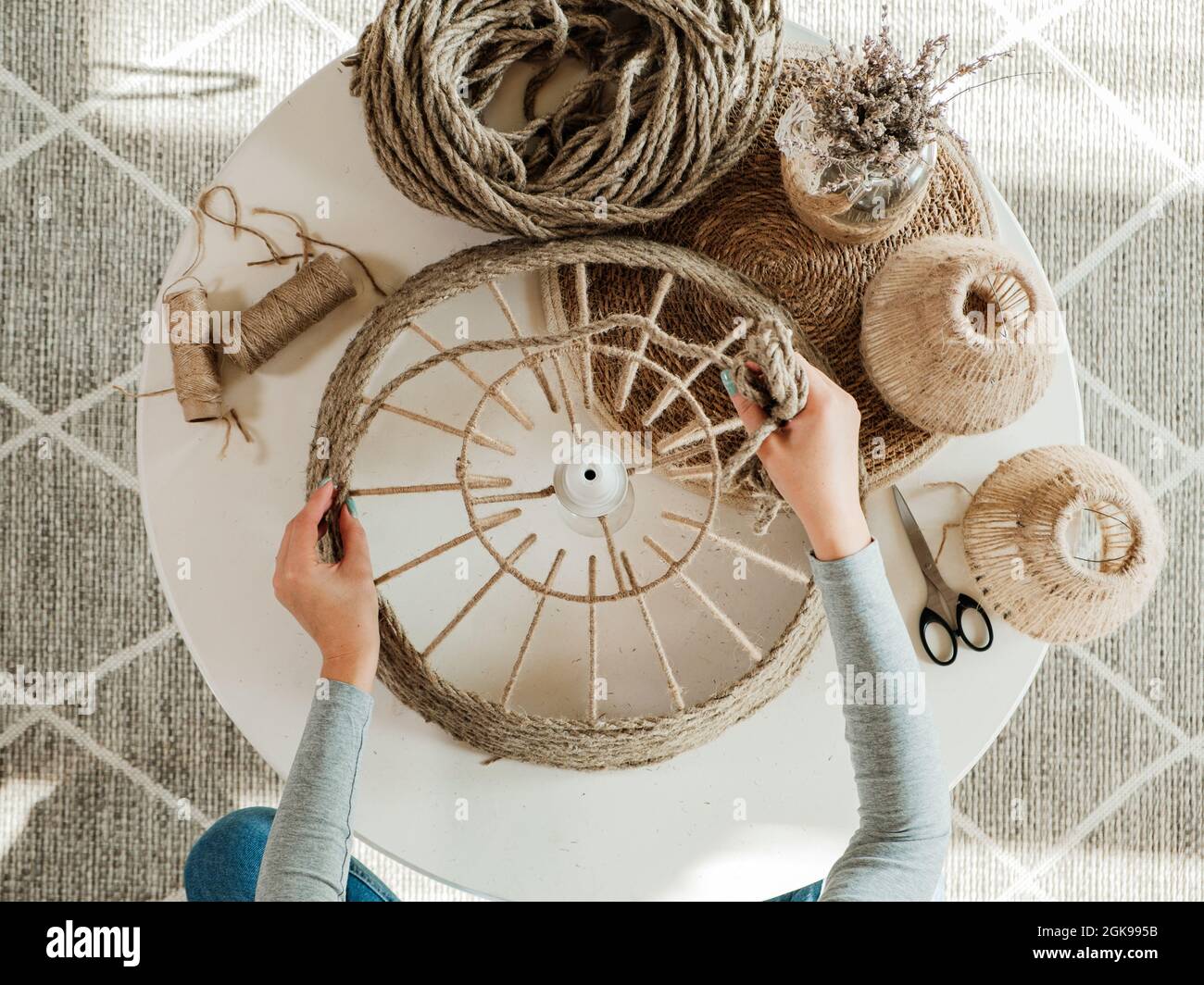 Woman makes handmade diy lamp from jute rope Stock Photo - Alamy