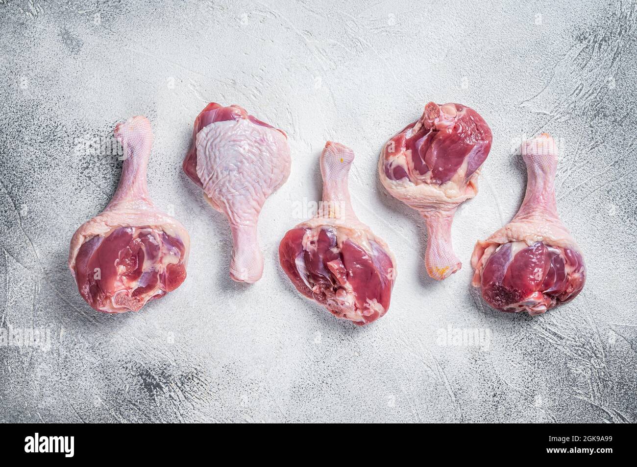 Raw Duck legs drumsticks on butcher table. White background. Top view ...